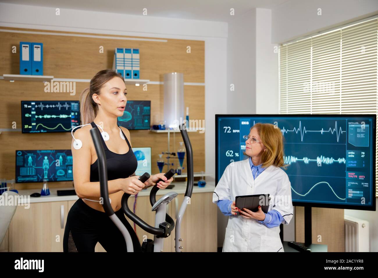 Female athlete testing the stepper with electrodes on her and the ...