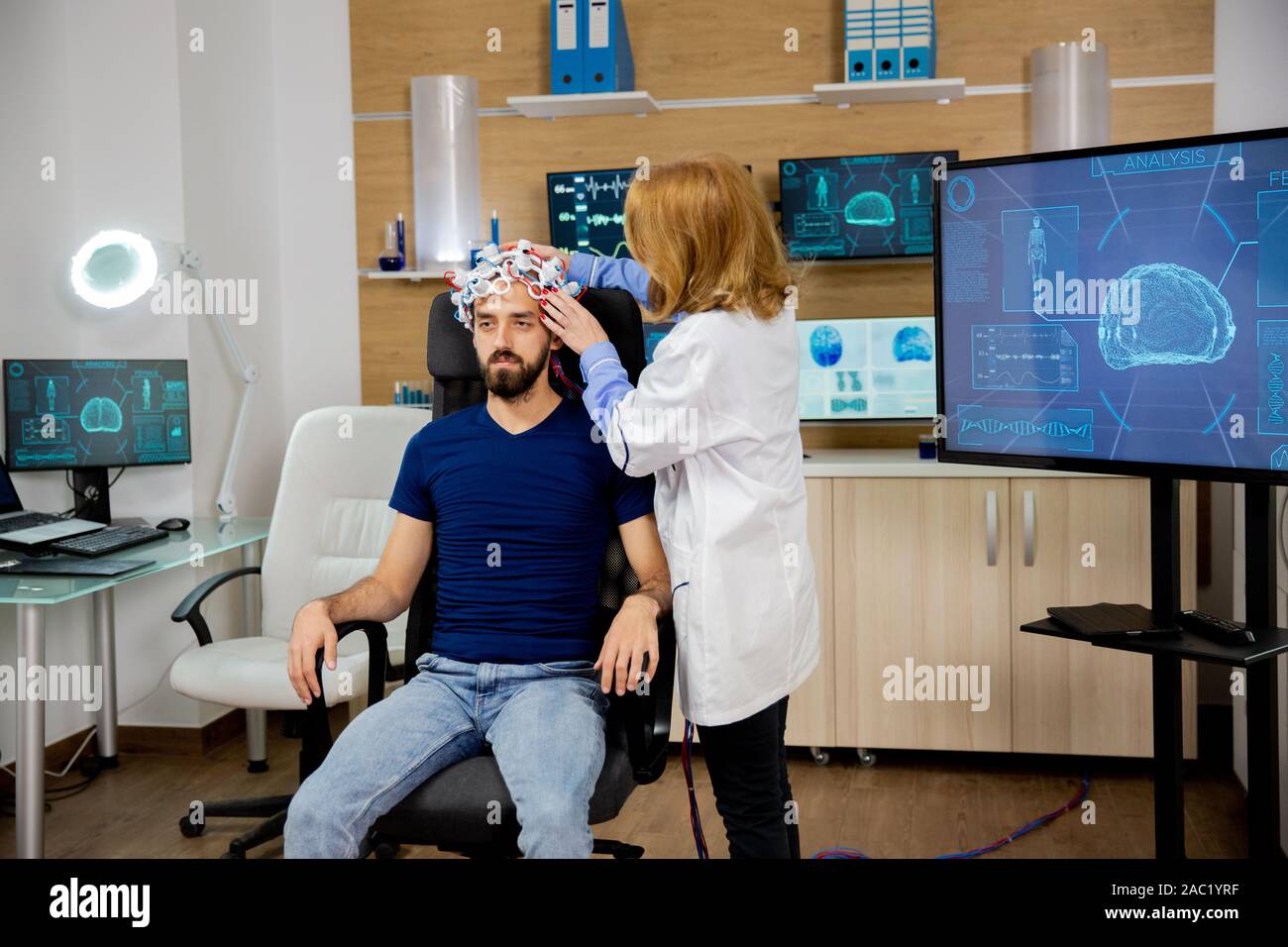 Doctor who puts brain waves scanning device on a male patient. Clinical ...