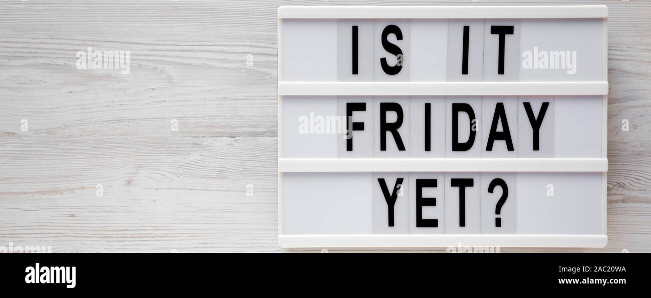 'Is it friday yet ?' words on a modern board on a white wooden surface ...