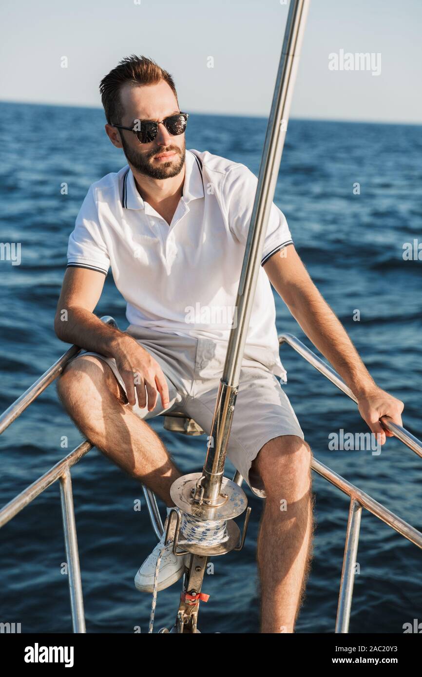 Photo of handsome serious attractive man outdoors posing on yacht in ...