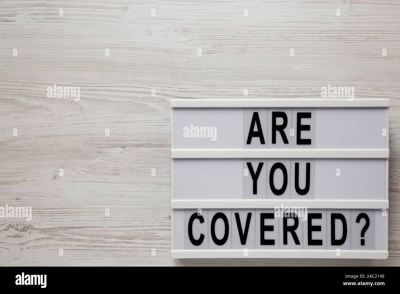 'Are you covered?' words on a modern board on a white wooden background ...