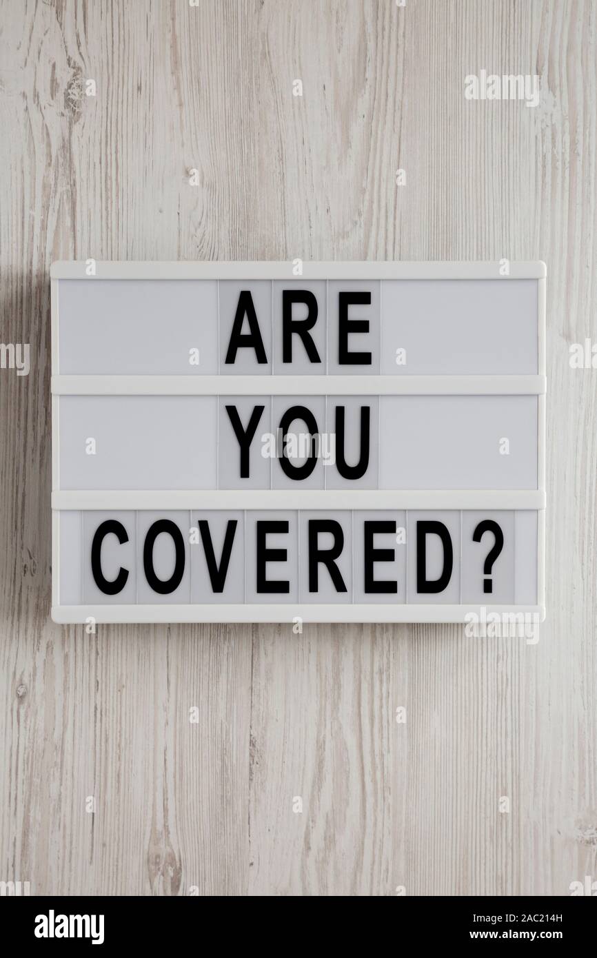 'Are you covered?' words on a modern board on a white wooden surface ...