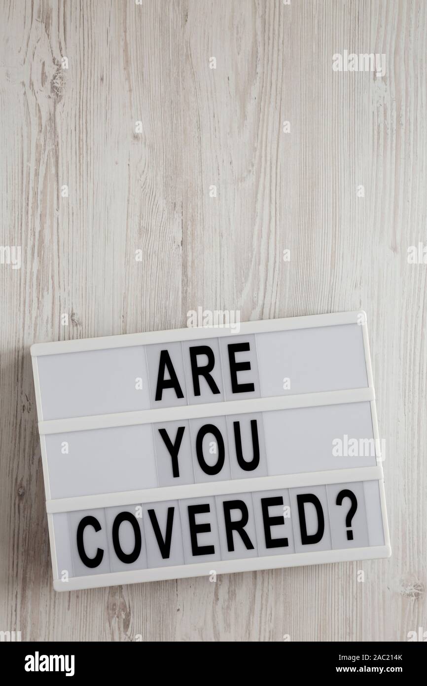 'Are you covered?' words on a modern board on a white wooden background ...