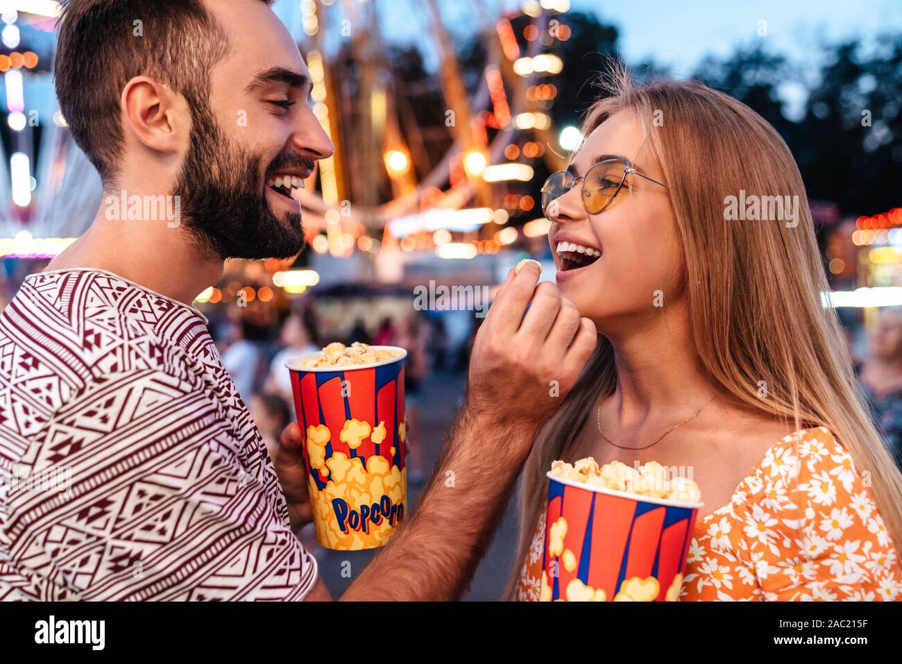 Photo of a happy positive loving couple walking outdoors in amusement ...