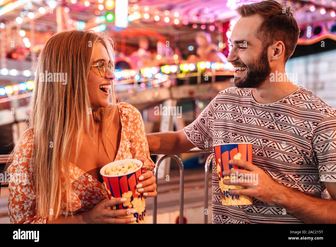 Photo of a happy positive loving couple walking outdoors in amusement ...