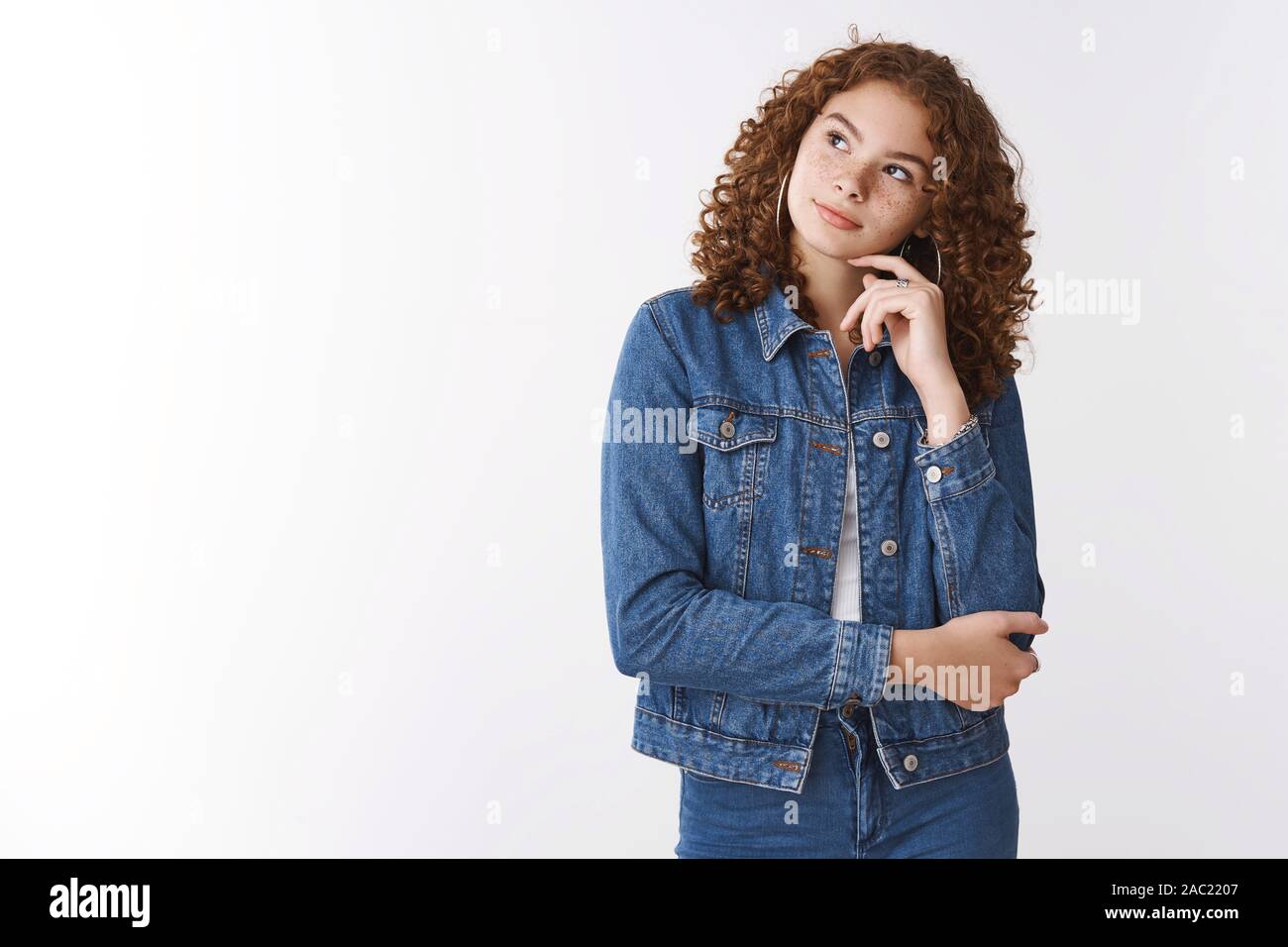 Dreamy thoughtful cute ginger girl curly-haired wearing denim lean head ...