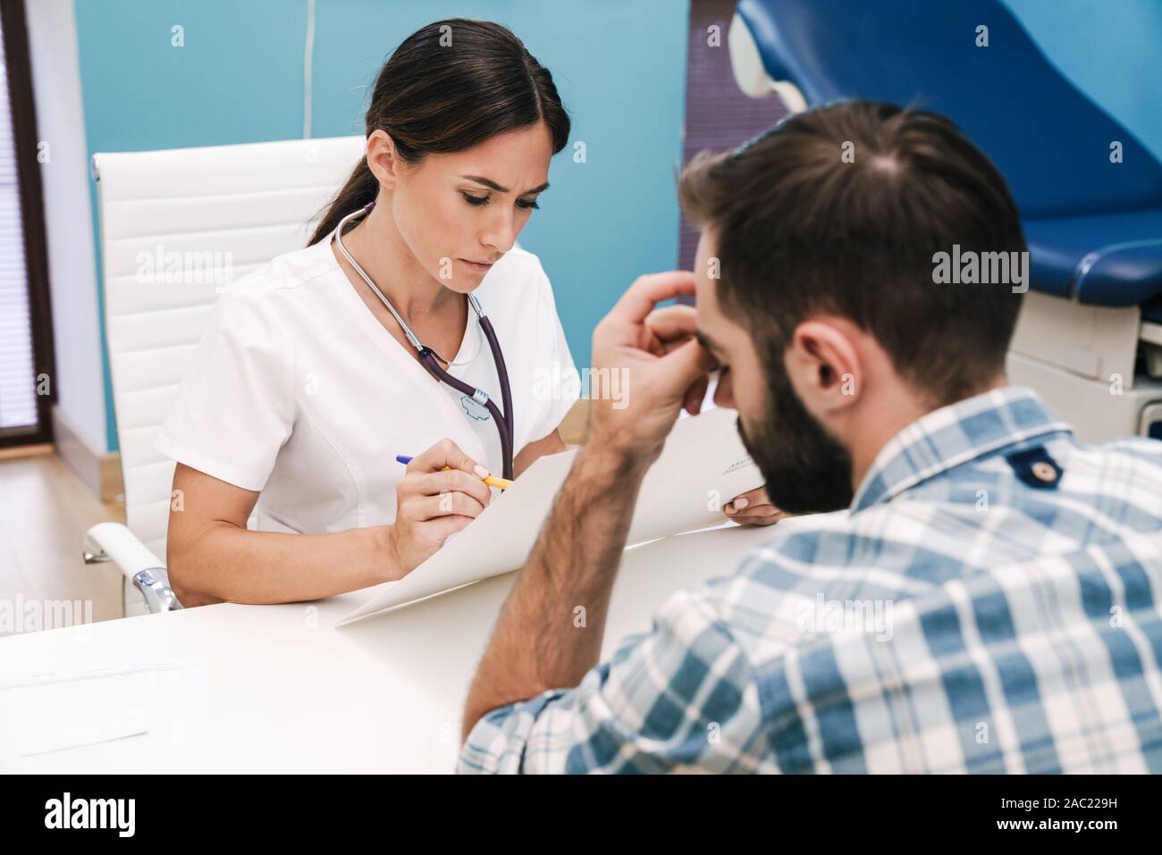 Image of concentrated serious doctor talking with her stressed sad ...