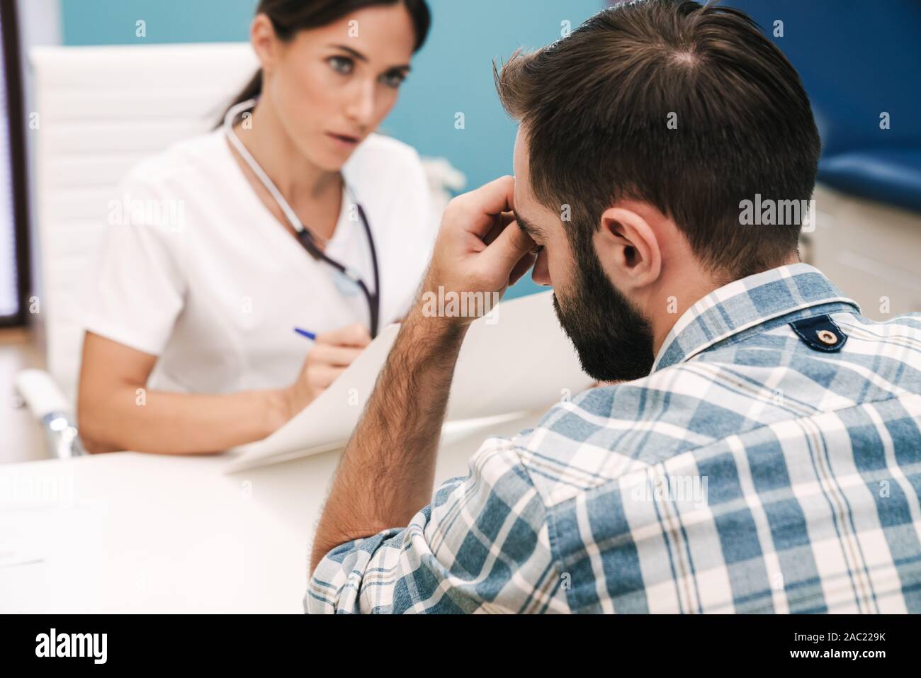 Image of concentrated serious doctor talking with her stressed sad ...