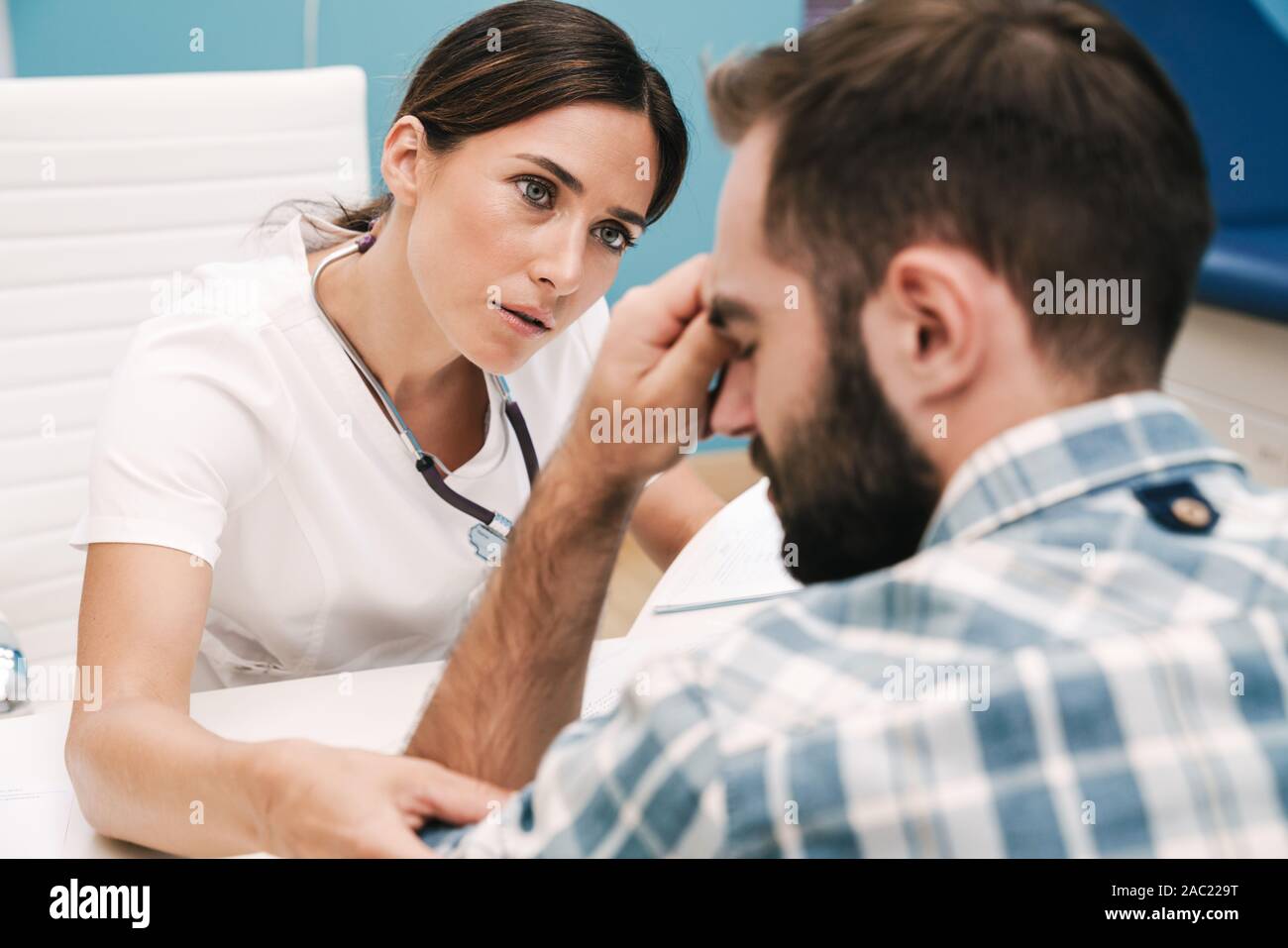 Image of concentrated serious doctor talking with her stressed sad ...
