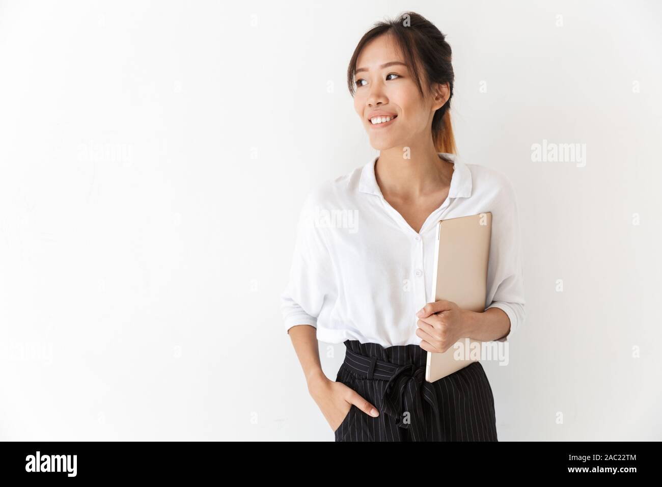 Attractive smiling asian woman standing isolated over white background ...