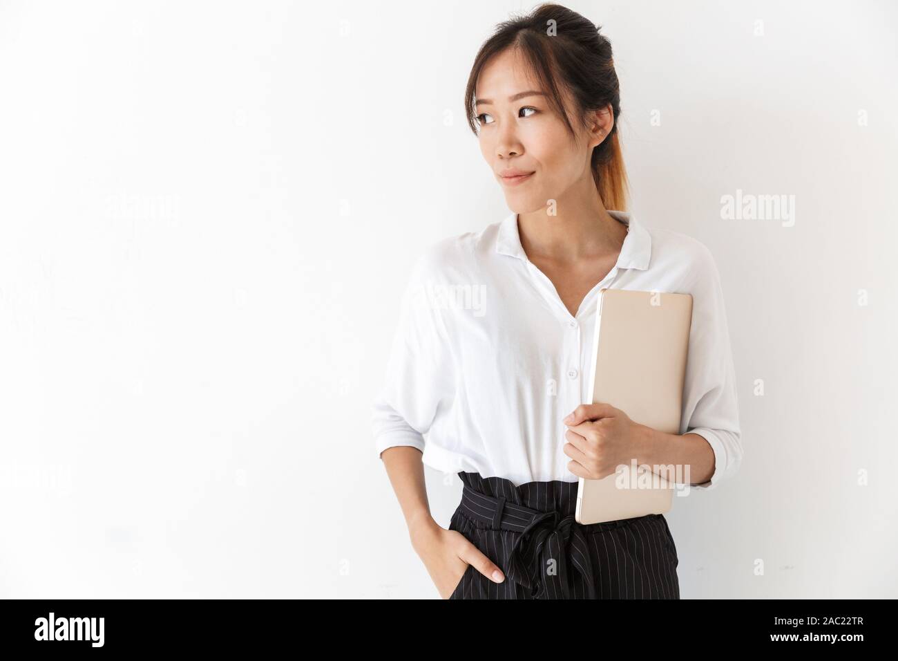 Attractive smiling asian woman standing isolated over white background ...