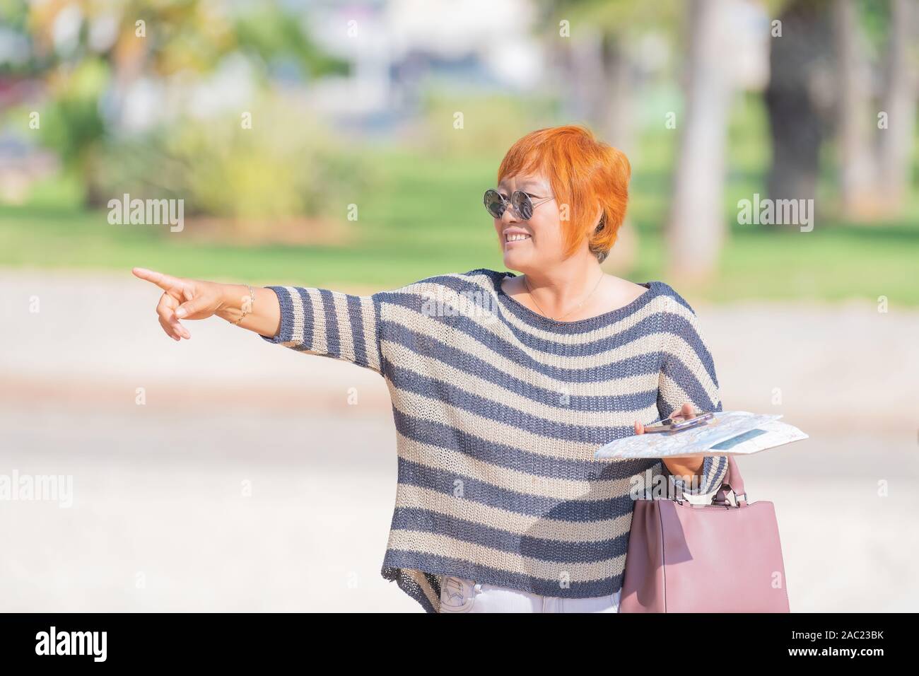 Asian woman searching direction on map Stock Photo - Alamy