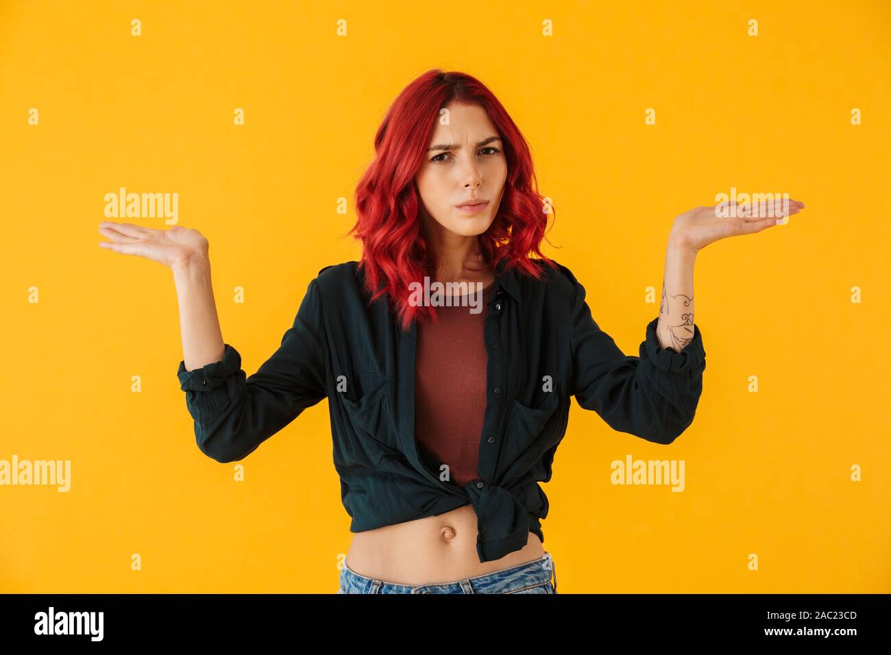 Image of attractive perplexed woman with curly red hair looking at ...