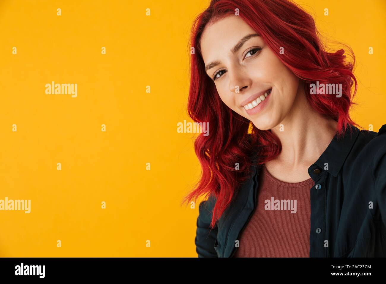 Image of happy young woman with curly red hair smiling and taking ...