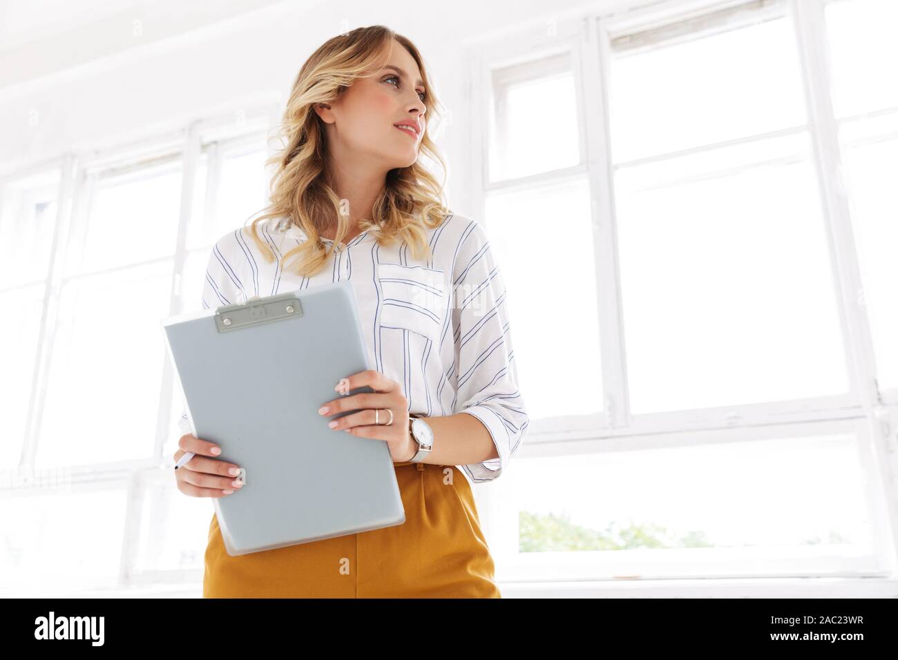 Image of pretty elegant secretary woman holding clipboard in white ...