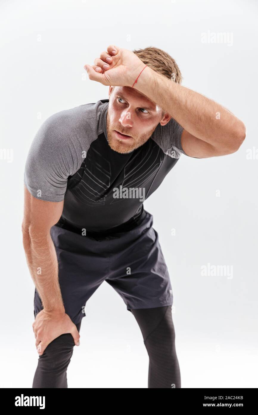 Portrait of a tired fit sportsman resting after work out isolated over ...