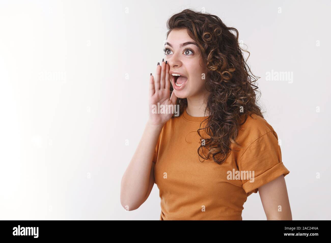 Cute armenian curly-haired girl yelling loud turn left hold palm open ...