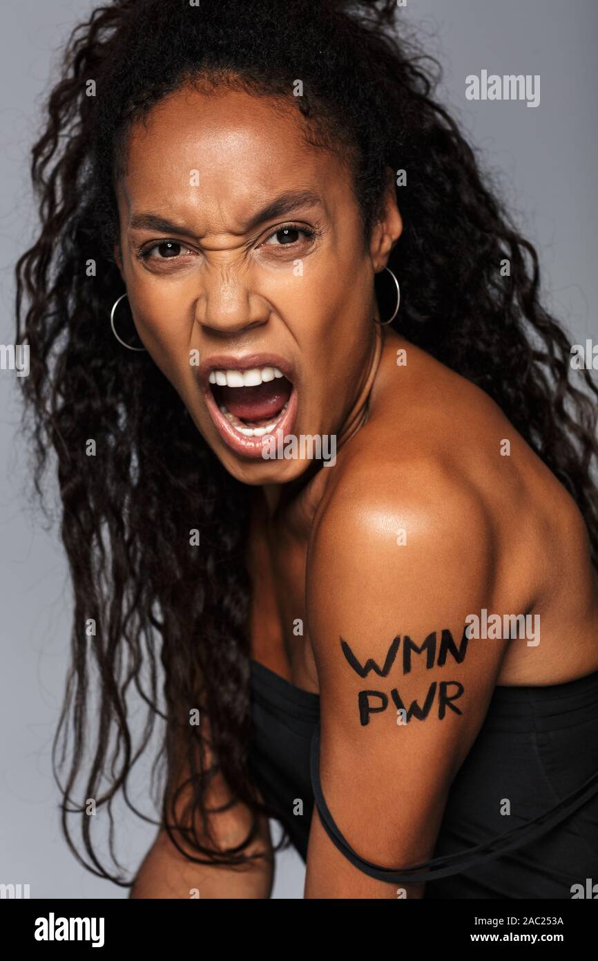 Portrait of a beautiful angry young african woman feminist standing ...