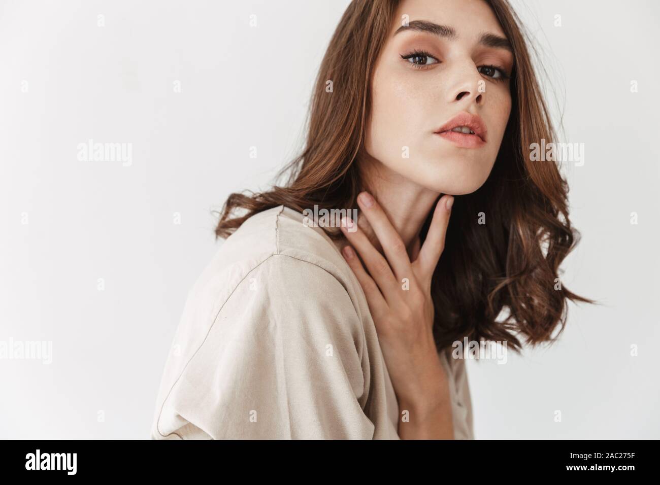 Photo of young beautiful woman touching neck posing indoors isolated ...