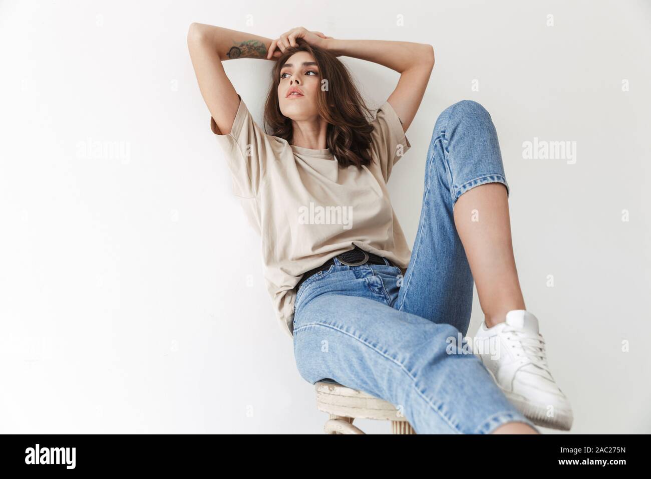 Photo of young beautiful woman posing indoors isolated over white wall ...