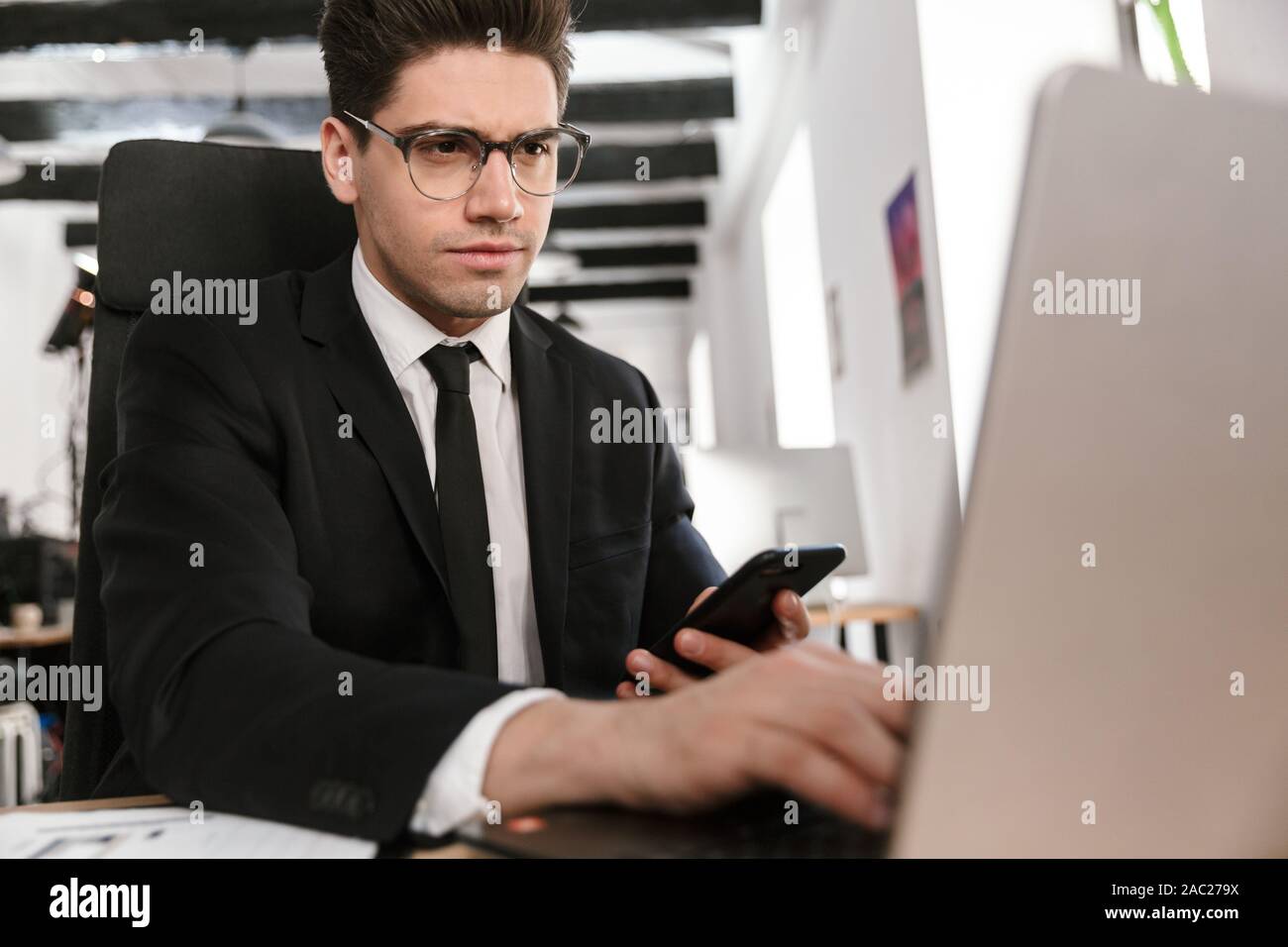 Focused businessman using computer in open plan office hi-res stock ...