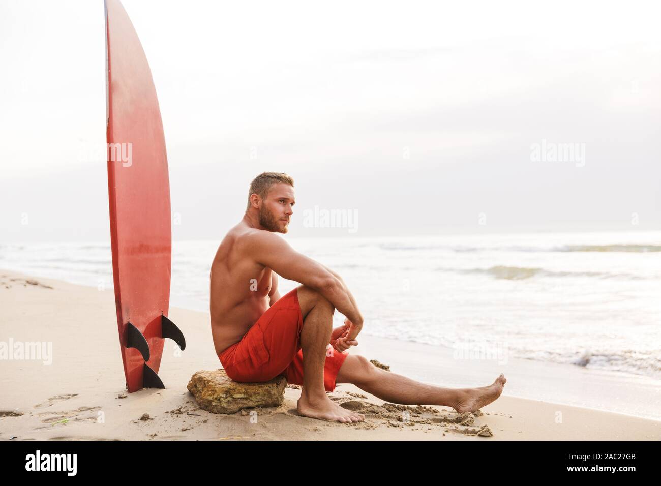 Image of a concentrated strong young handsome man surfer with surfing ...
