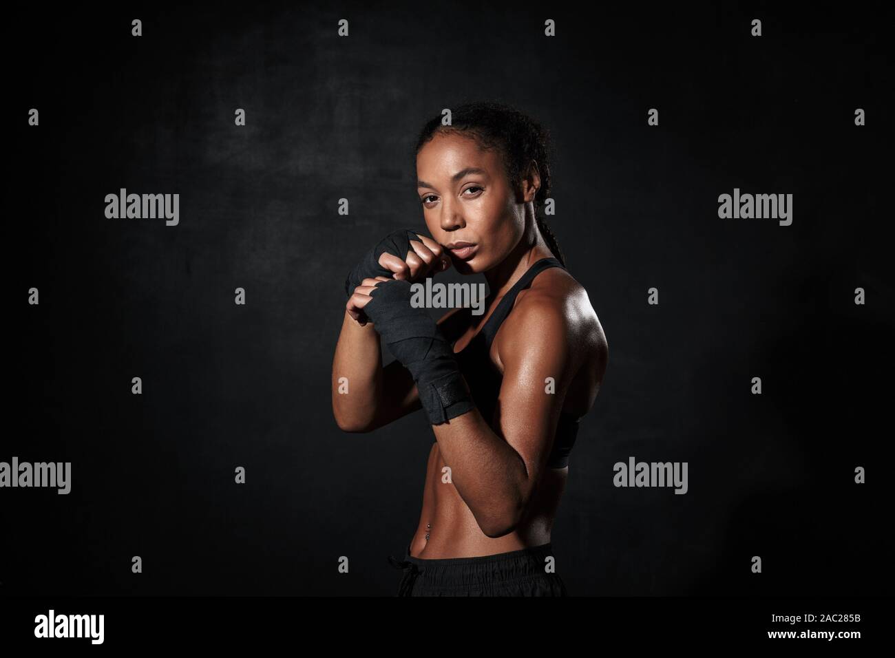 Image of strong african american woman wearing sportswear boxing in ...
