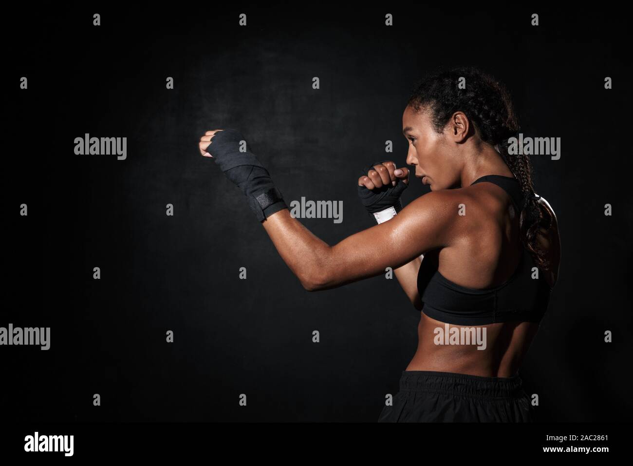 Image of healthy african american woman wearing sportswear boxing in ...