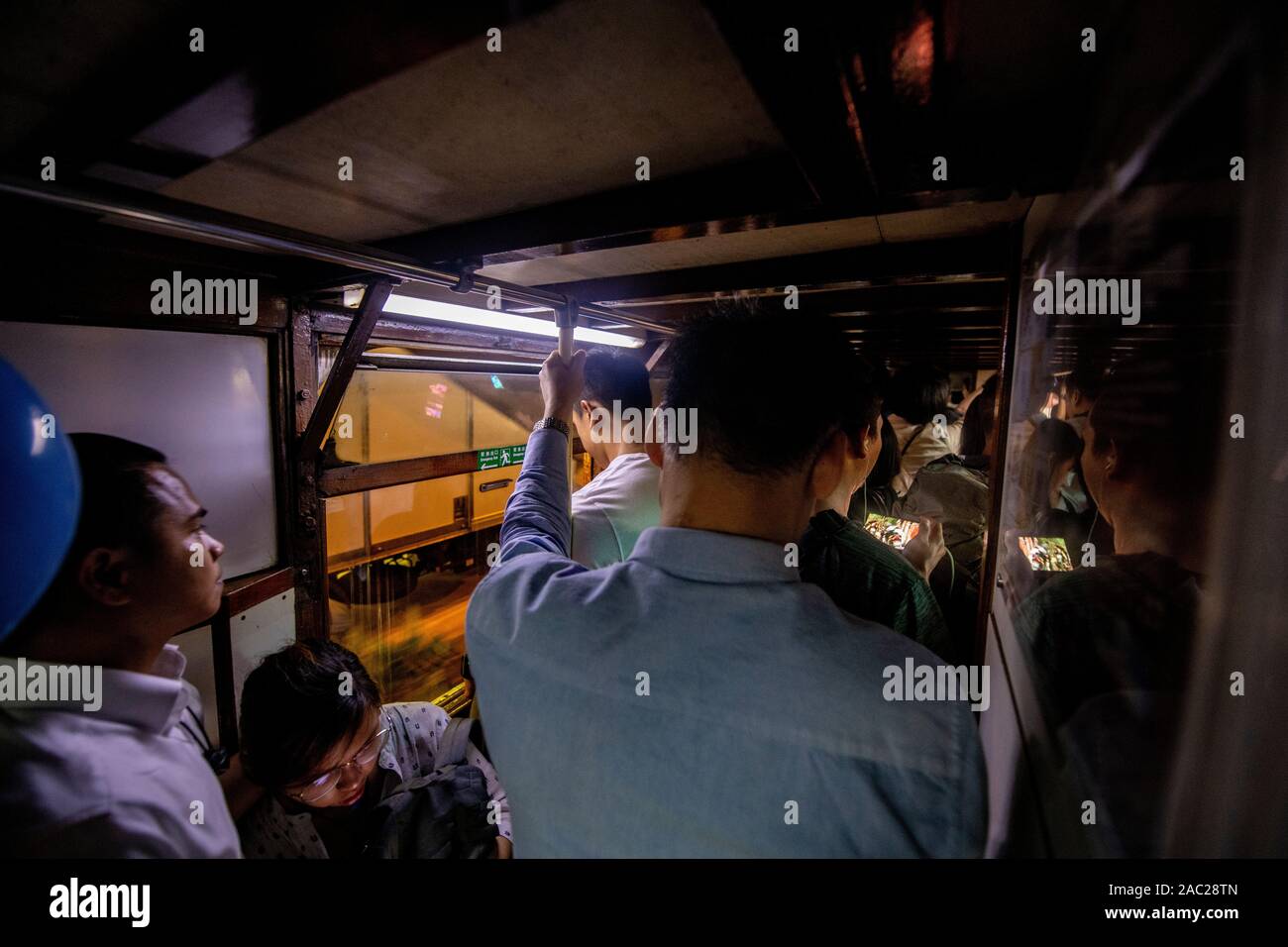 The interior of a crowded tram in rush hour in the centre of Hong Kong ...
