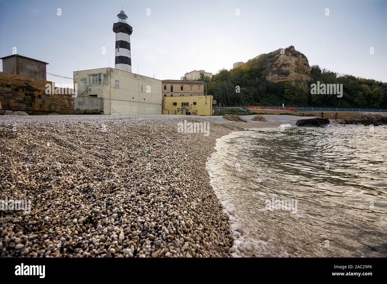 The Faro di Ortona and its pebble beach at sunset Stock Photo - Alamy