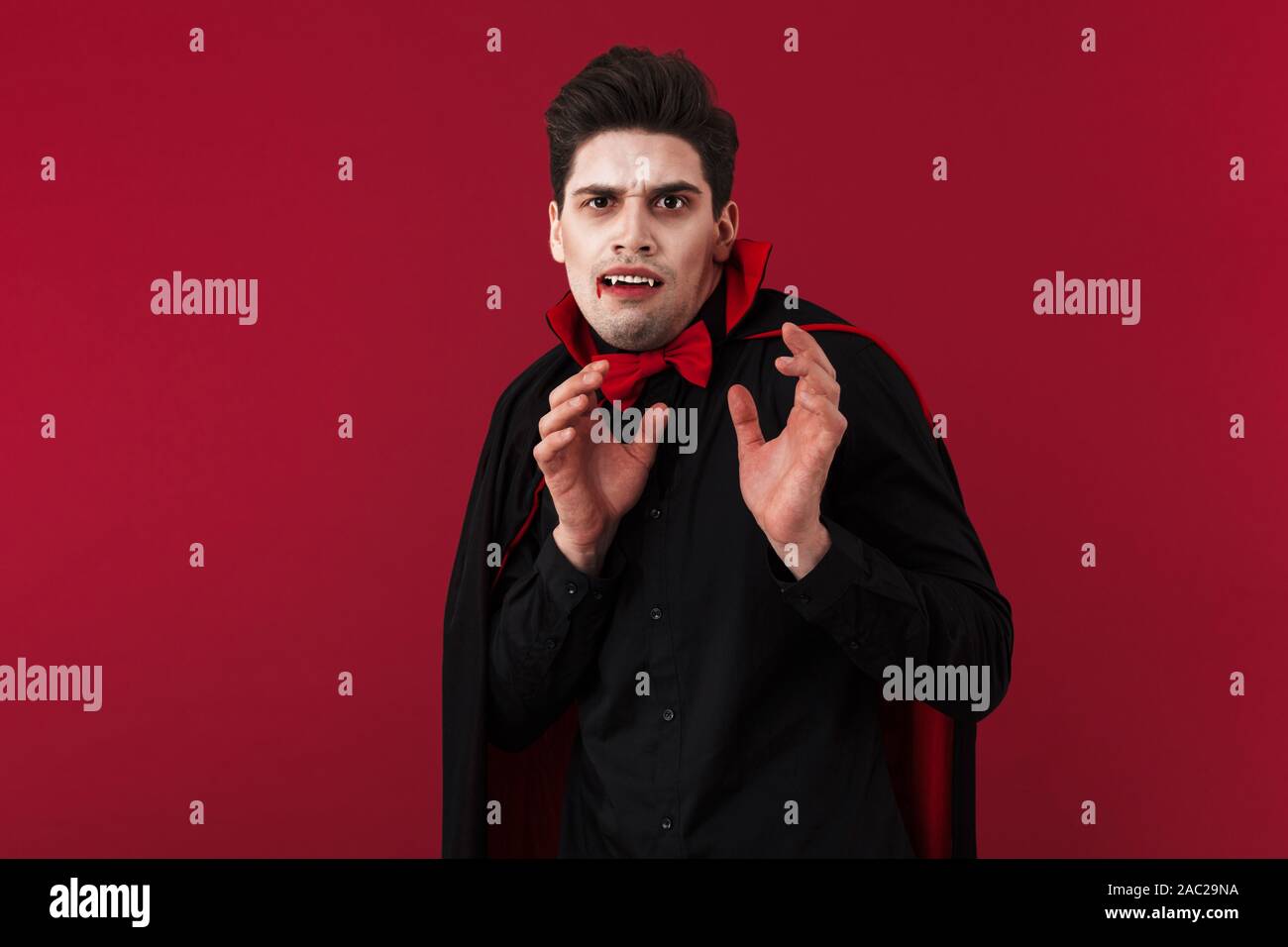 Image of young vampire man with fangs in black halloween costume being ...