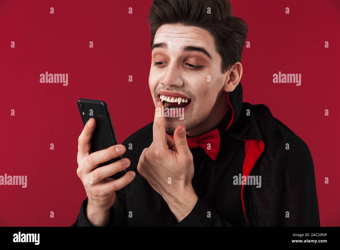 Image of vampire man with blood and fangs in black halloween costume ...