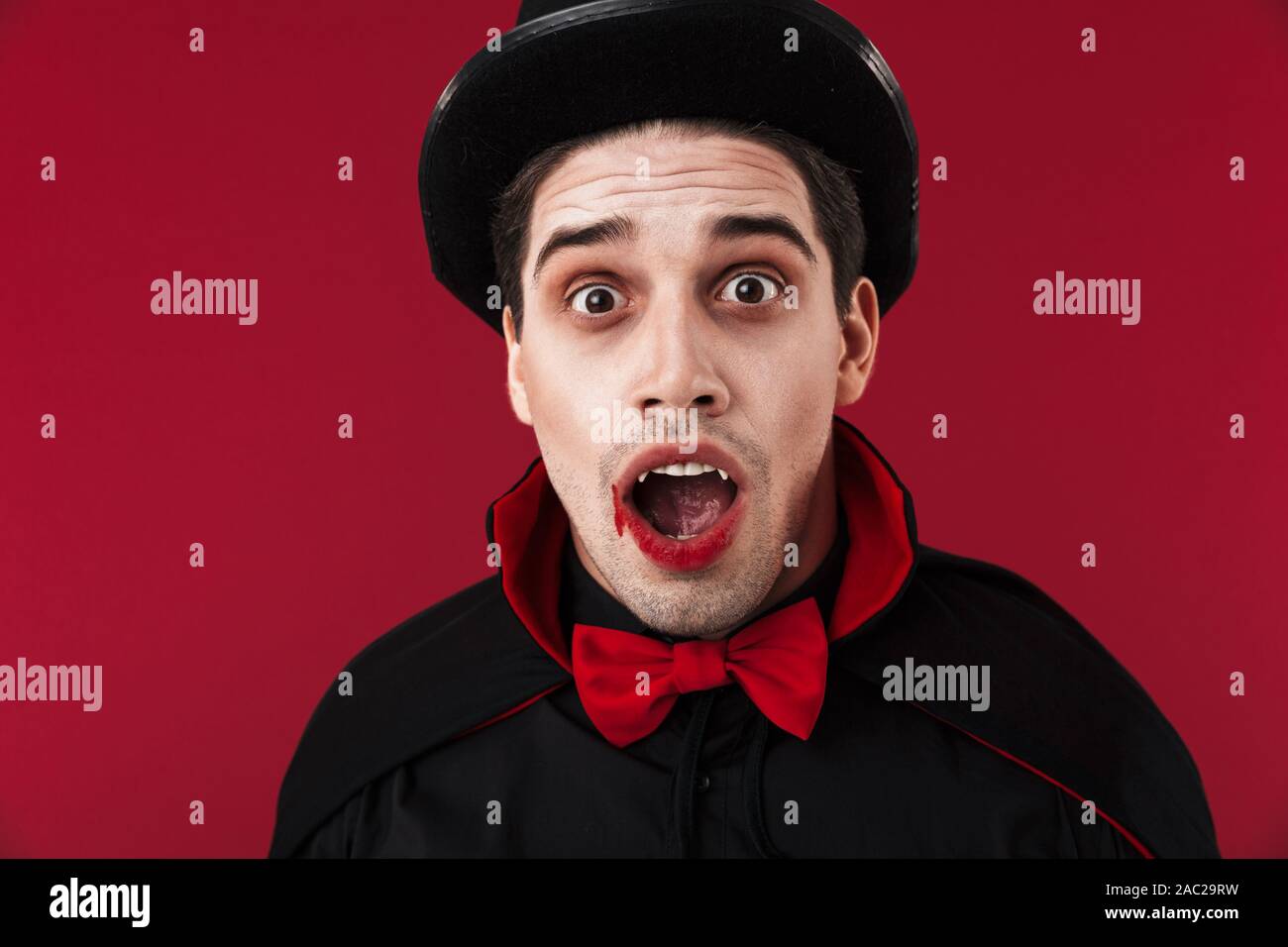 Image of surprised vampire man with blood and fangs in black halloween ...