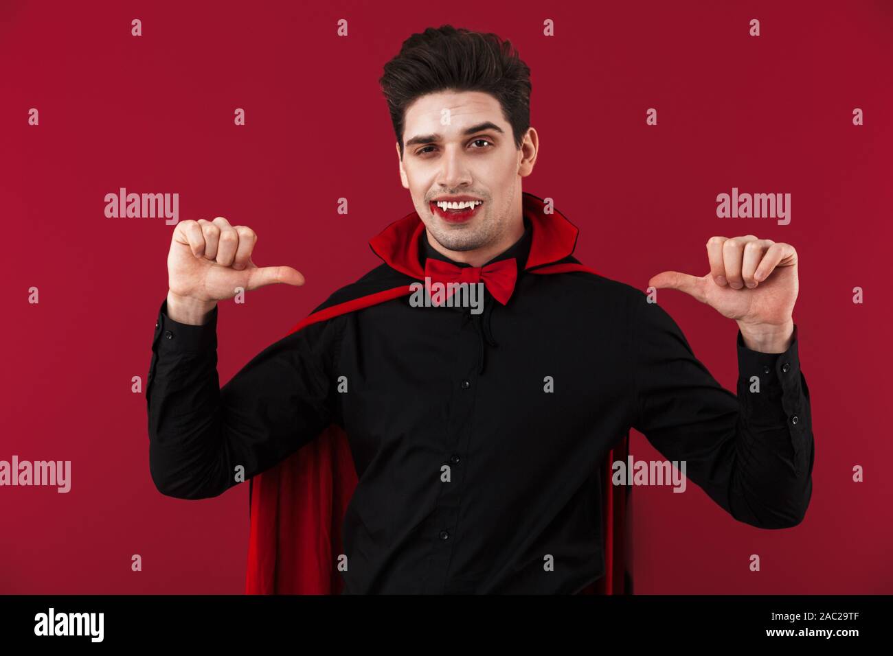 Image of pleased vampire man with blood and fangs in black halloween ...