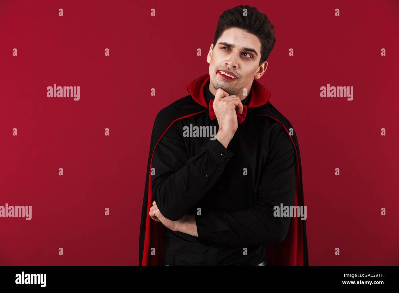Image of young vampire man with blood and fangs in black halloween ...