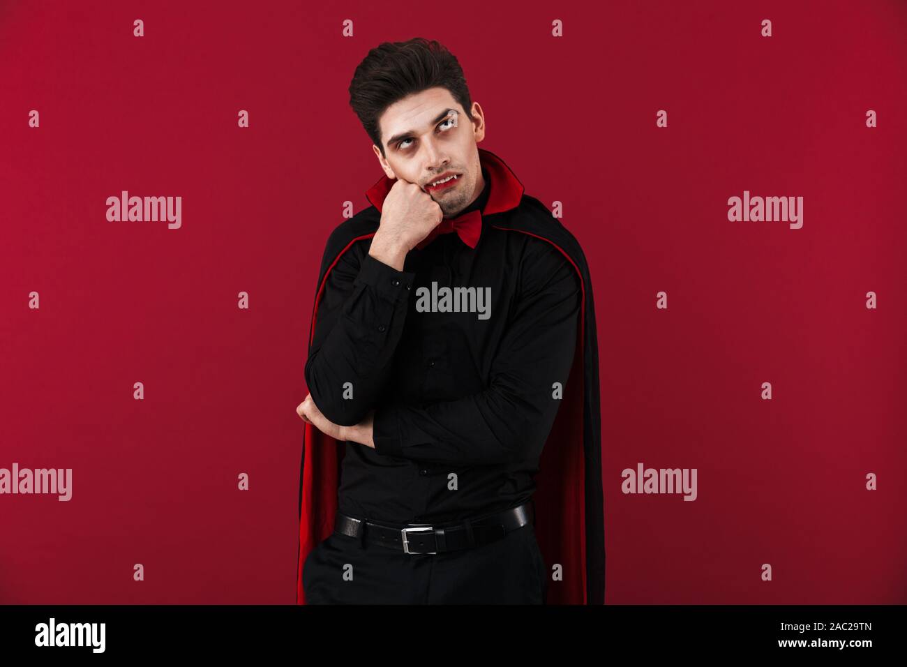 Image of thoughtful vampire man with blood and fangs in black halloween ...