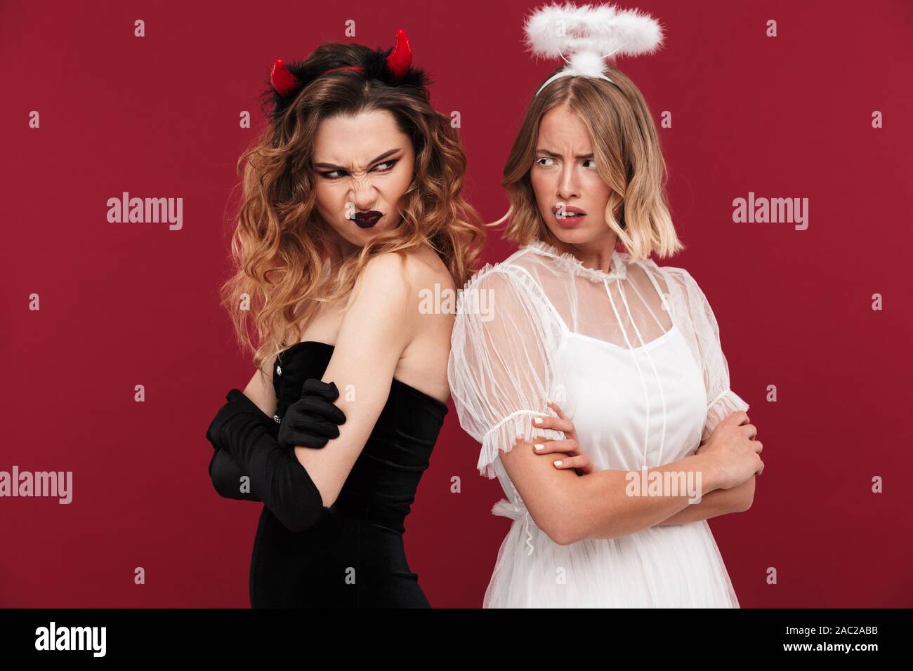 Photo of a displeased women angel and demon in carnival costumes ...