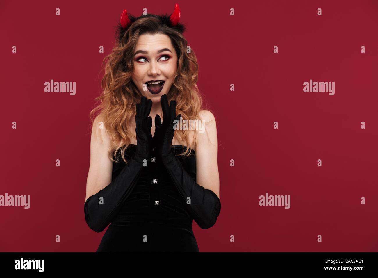 Image of thinking dreaming woman demon in carnival costume isolated ...