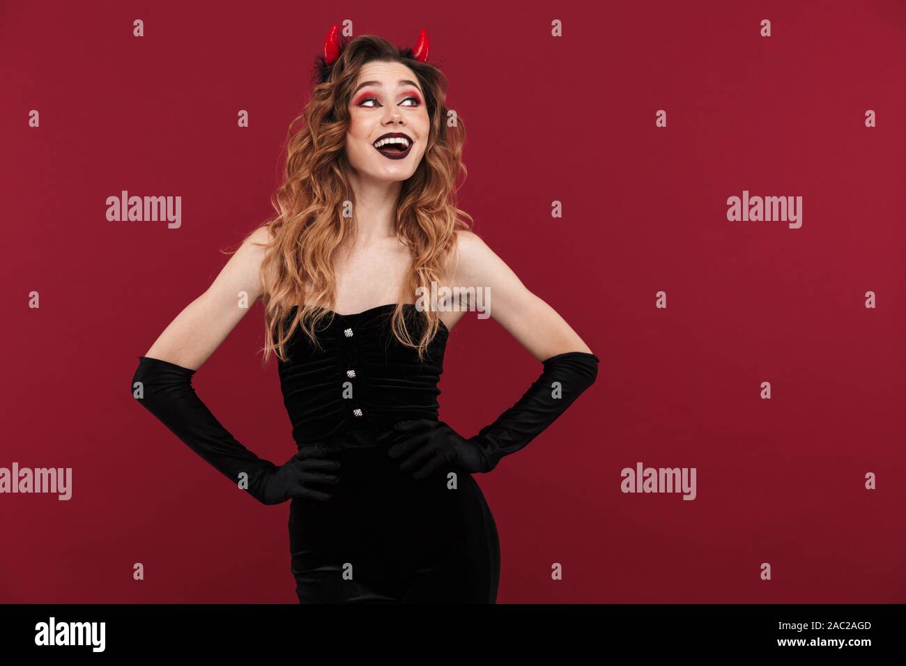 Image of happy cheery woman demon in carnival costume isolated over red ...
