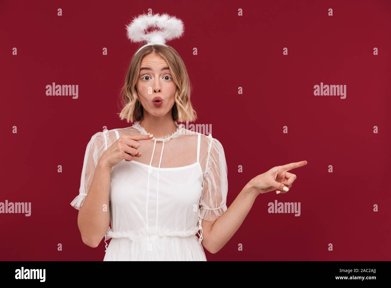 Photo of shocked emotional woman angel in carnival costume isolated ...