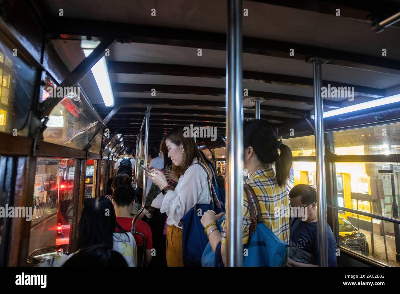The interior of a crowded tram in rush hour in the centre of Hong Kong ...