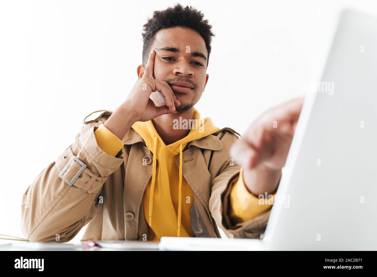 Image of perplexed african american man thinking while working on ...