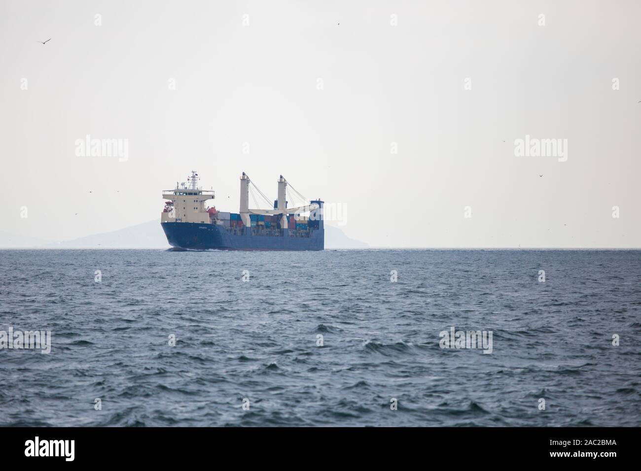 A cargo ship sails with the sea in the distance, delivery of goods ...
