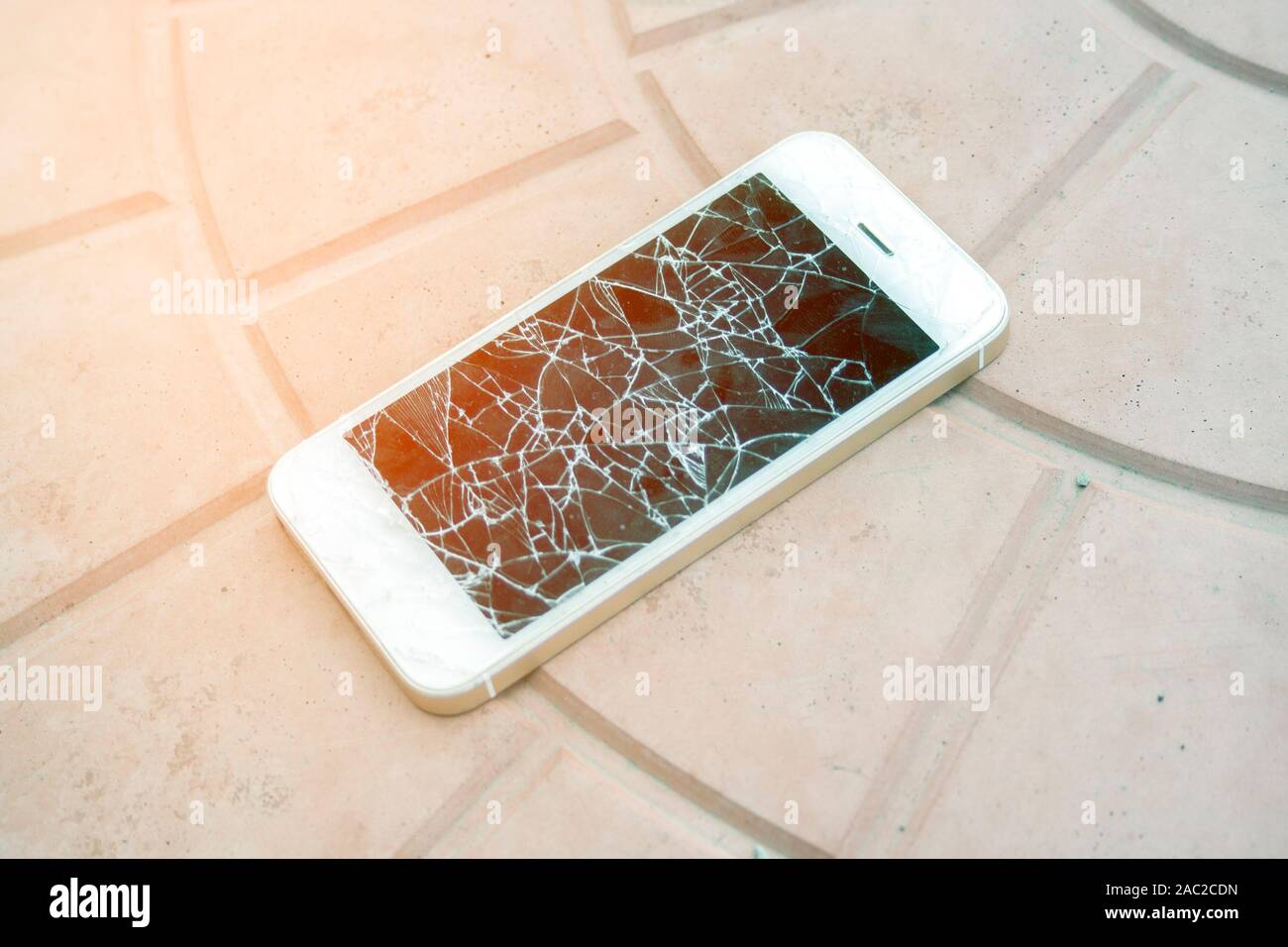 broken smartphone screen. Smartphone with a broken screen on the tile ...