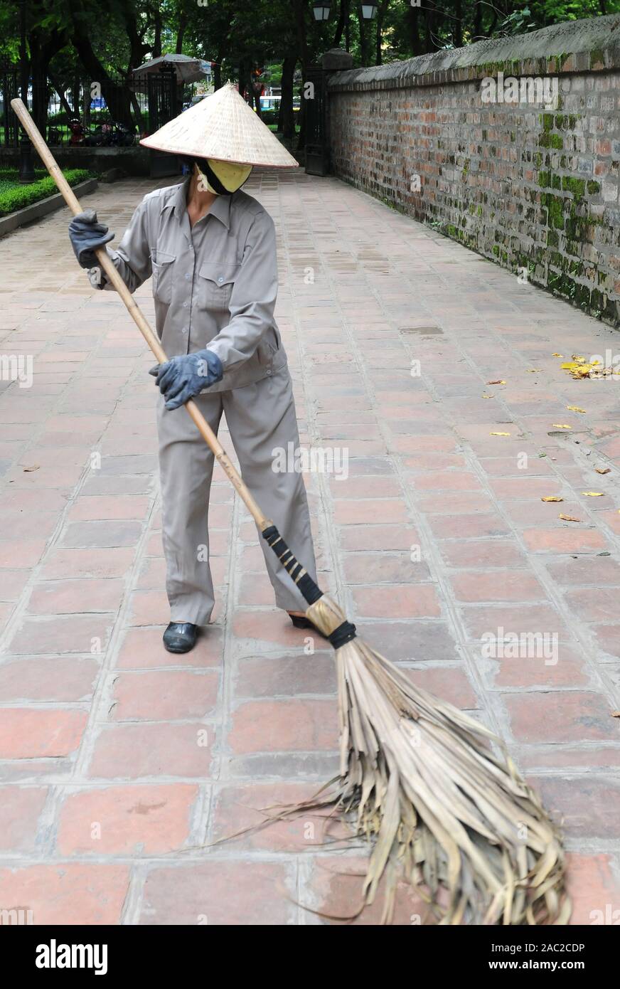 Vietnamese sweeper woman cleaning the pavement and road Stock Photo - Alamy