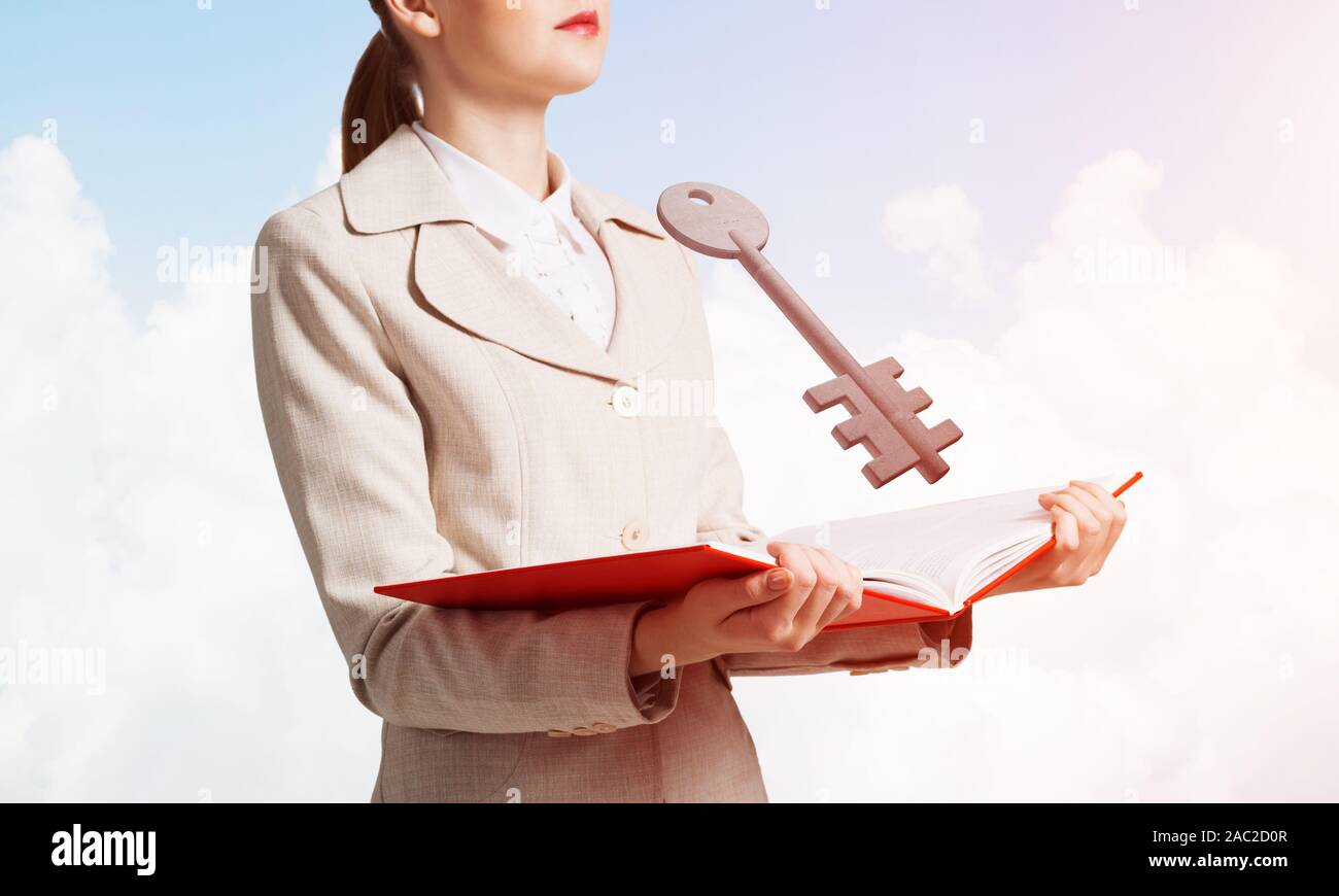 Woman showing big metal key Stock Photo - Alamy