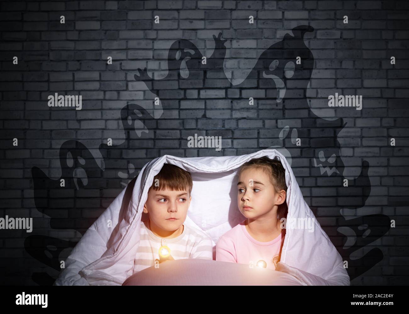 Scared girl and boy with flashlighst Stock Photo - Alamy