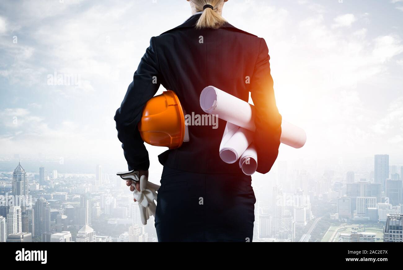 Architect standing with construction drawings Stock Photo - Alamy