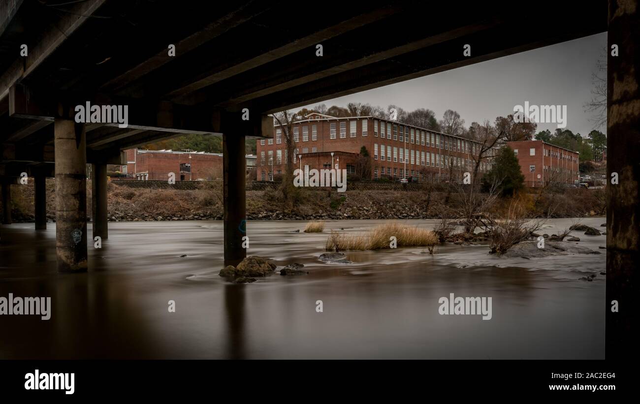 Industrial building framed by bridge spanning Haw river in Saxapahaw ...