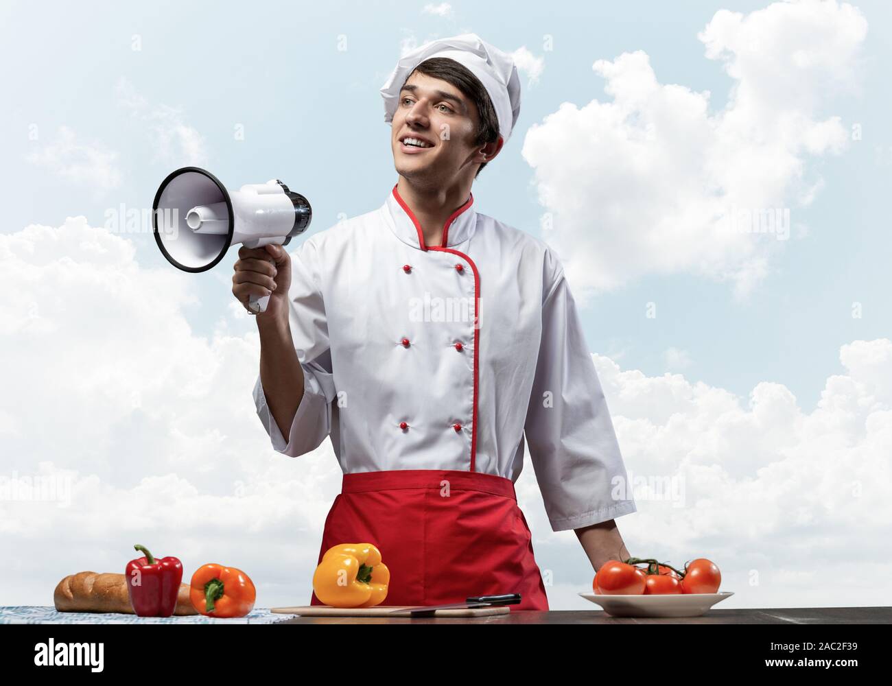 Young chef standing with megaphone in hand Stock Photo - Alamy
